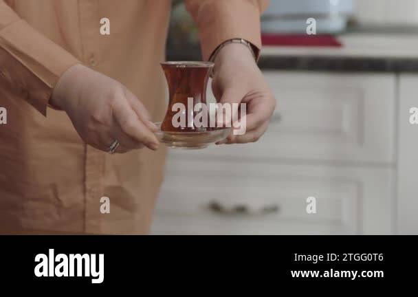 Spilled beverage with care. Pouring the tea on the ground.Close-up ...