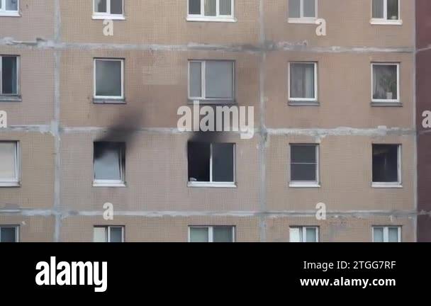 Fire in an apartment building. Gray smoke billows from the windows of ...