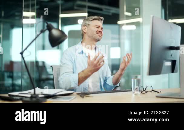 Angry mature business man worker working on computer in office. Upset ...