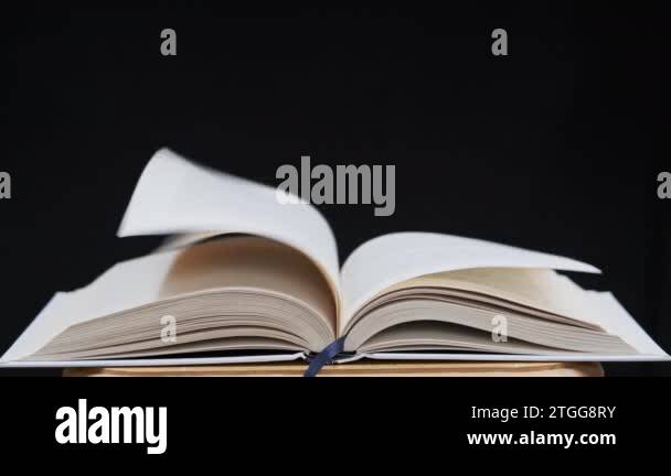The pages of the book are turning on their own in slow motion, close-up ...