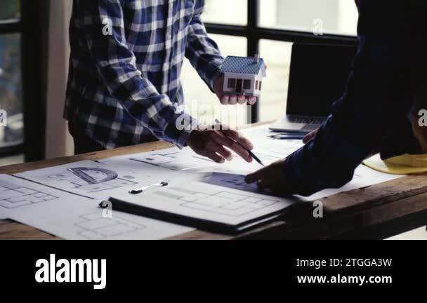 Engineers and architects discuss construction plans. Work on the blueprints on the desk in the ...