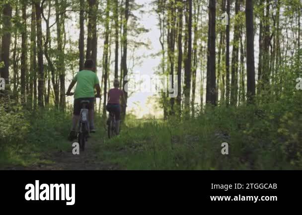 Family on a bike ride in the woods. Woman with baby riding off-road ...