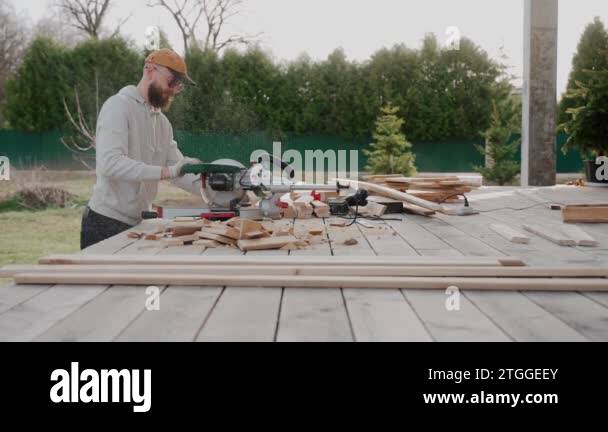 Man cutting wood using table saw on construction site of a modern ...