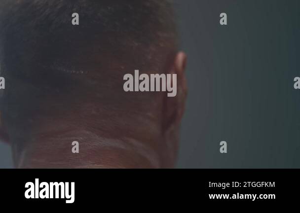 An athletic male back is covered with white clay, the man turns his ...