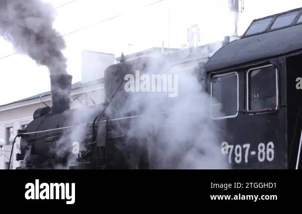 Steam locomotive train approaching station passing through goods yard ...
