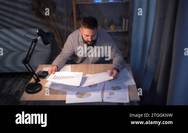 businessman working with tables, graphs, diagrams, makes calculations ...