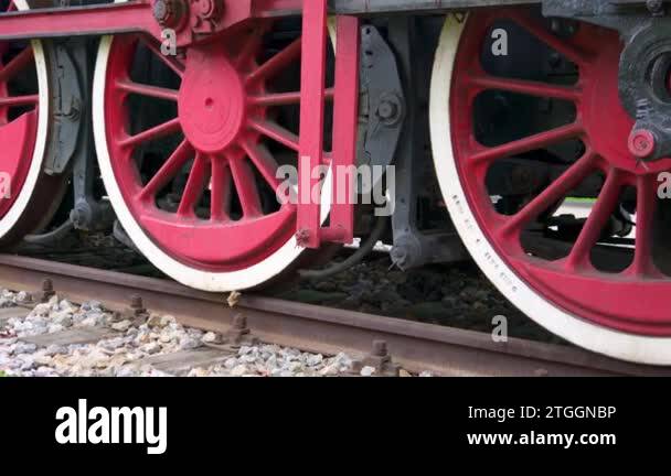 Steel red wheels with a white rim of a steam locomotive on rusty metal ...