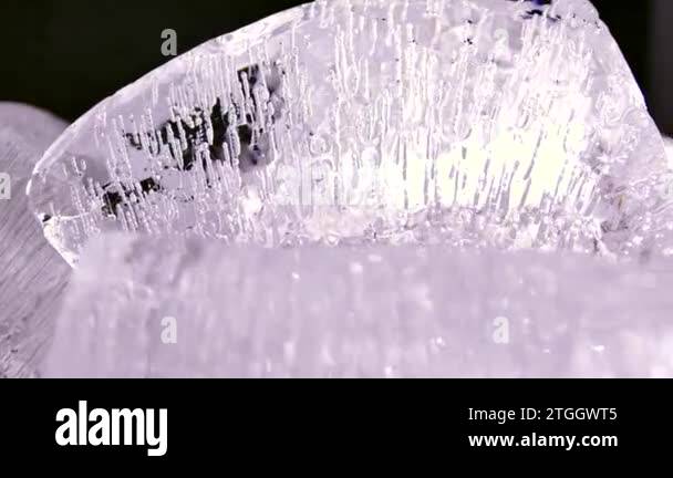 Pieces of ice with frozen air bubbles shine through with light. Frozen ...