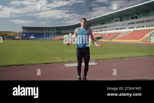 Tired young athlete jumping with rope during training on arena Stock ...