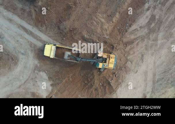 Aerial shot of site mining ground. Drone flying over excavator digging ...