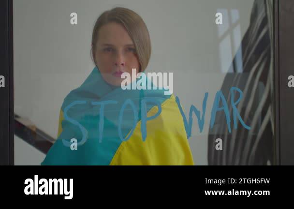 Sad charming middle aged woman wrapped in Ukrainian flag wishing for ...