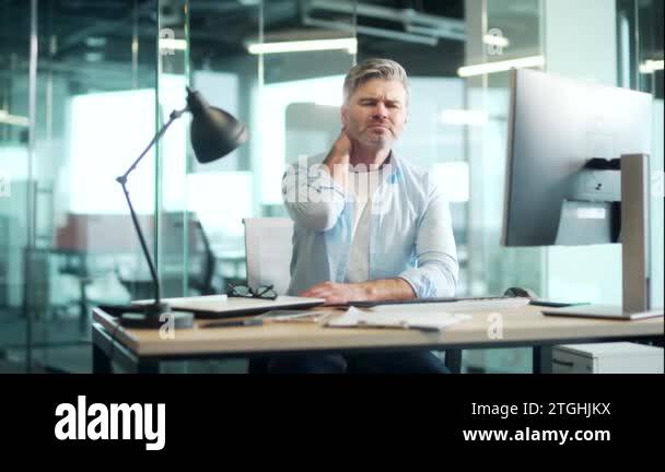 Mature business male employee with pain in the muscles of the neck and ...