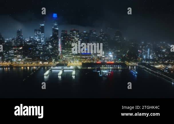 San Francisco cityscape illuminated at night, flight over foggy city ...