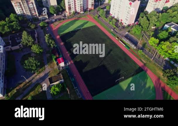 Buildings with street in small town with empty football soccer field ...