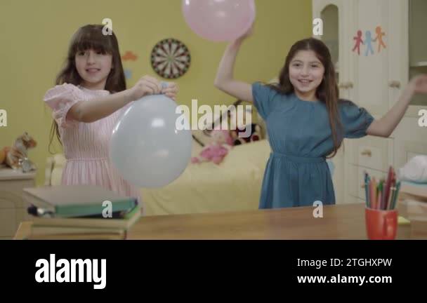 Little girls are blowing air into the balloon. Happy birthday party ...