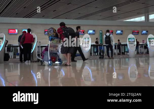 CHANGI AIRPORT, SINGAPORE - MARCH 30, 2019 : Passengers passing through ...