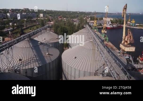 Modern grain elevator terminal in sea port. Metal tanks and conveyors ...