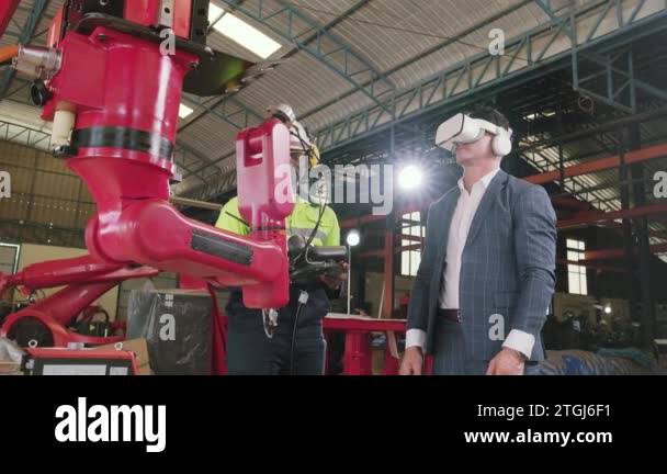 African American engineer demonstrates robotic arm control to customer ...
