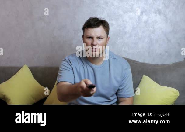 Switching TV channels. Dead battery in tv remote. Angry young man ...