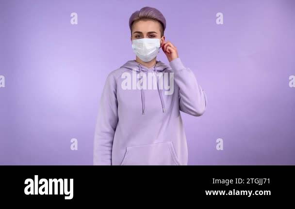 Stylish young adult woman generation Z taking off medical face mask ...