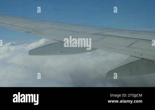 Entry of an airplane wing into thick white clouds. Beautiful shots in ...