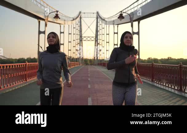 Active muslim runners wearing hijabs and sportswear competing in speed ...