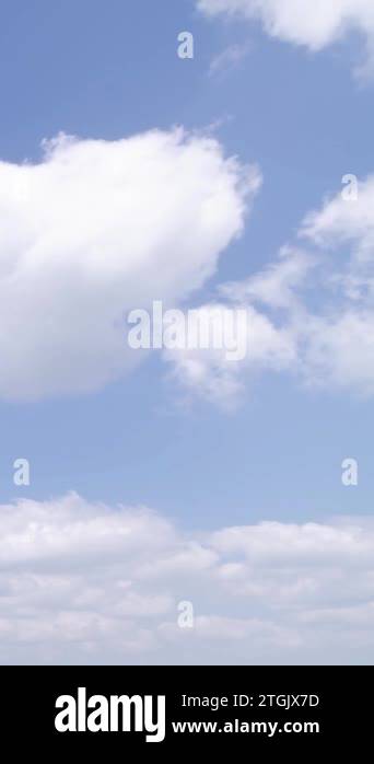 vertical timelapse view of Blue sky white puffy fluffy white clouds ...