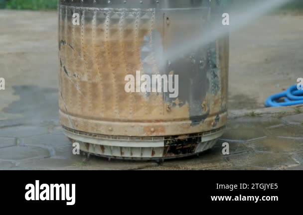 Close-up of washing machine drum descaling with high-pressure cleaner ...