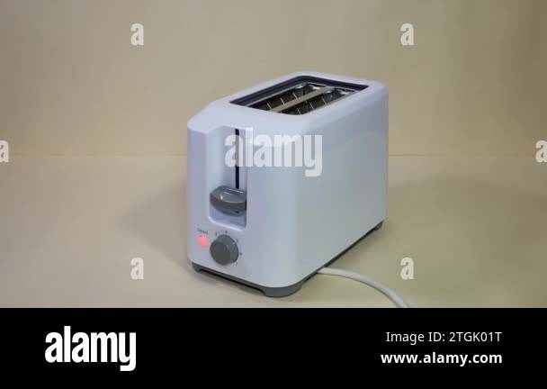 Close up sliced roasted white bread popping from electric toaster ...