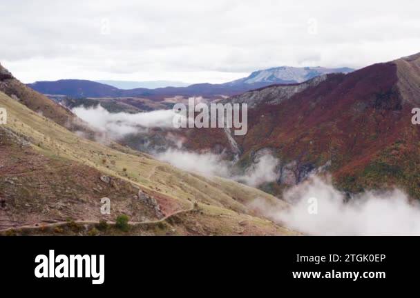 Drone flying over mountain ranges with cliffs and slopes on which grow ...
