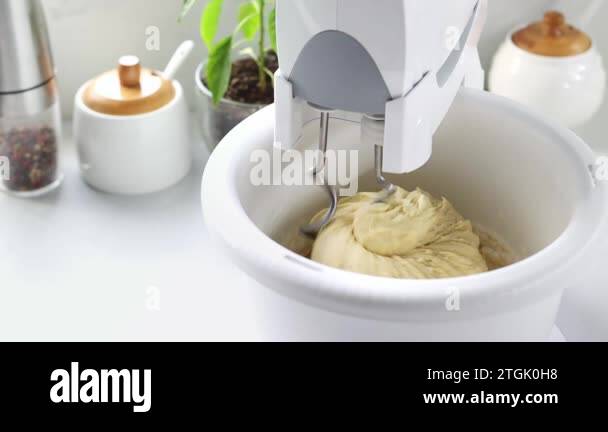 Mixer stirs the dough in a spinning bowl. A stationary mixer with a ...