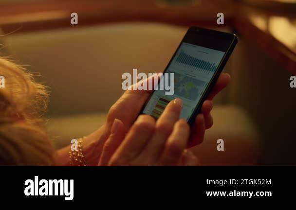 Hands holding data charts on cellphone closeup. Unknown manager working ...