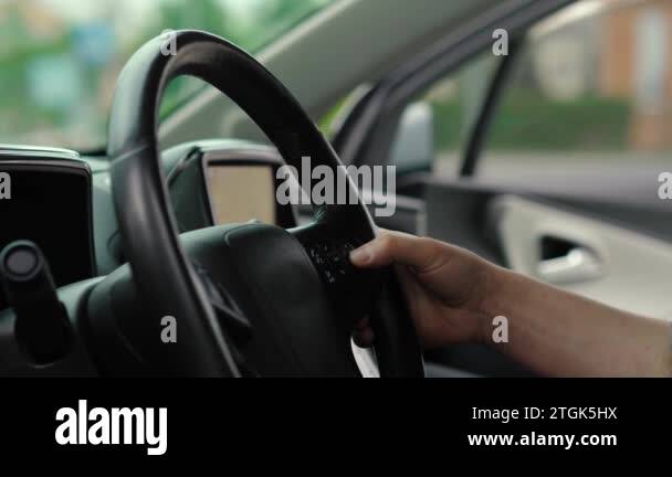 Male hand pushing buttons on steering wheel close up. Mans finger ...