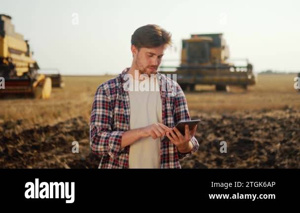 Precision smart farming. Farmer use digital tablet for combine ...
