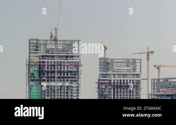 Tall buildings under construction and cranes in downtown timelapse ...