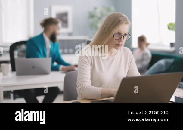 Concentrated business people working on laptop while sitting at modern ...