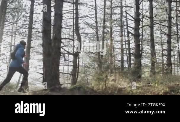 Trail runner in the woods wearing winter sports outfit. Man running on ...