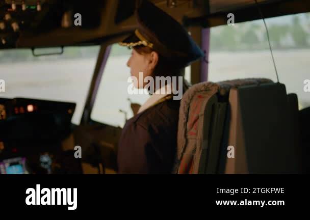 Portrait of aviation copilot using control panel command in cockpit, flying aircraft jet with ...