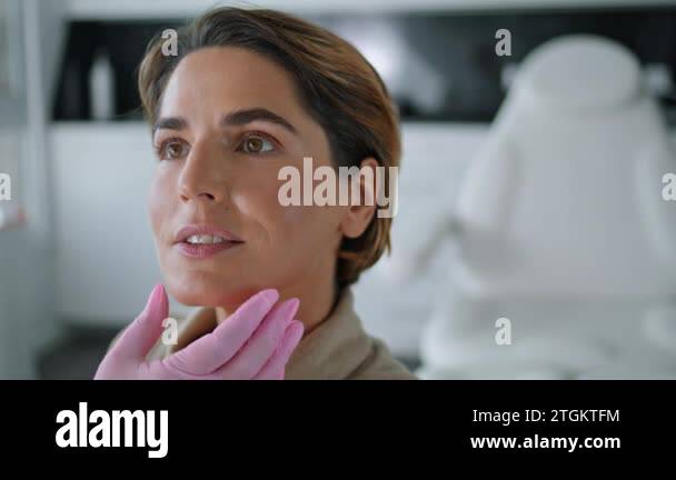 Unknown beautician checking skin health attractive woman sitting in ...