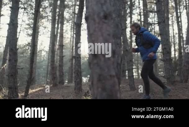 Trail runner in the woods wearing winter sports outfit. Man running on ...