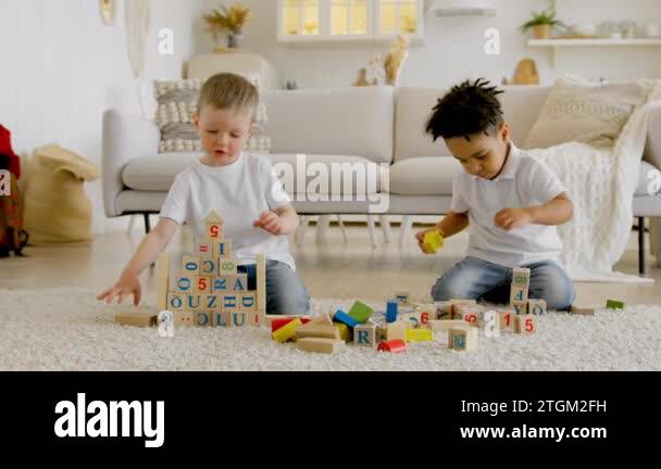 Two happy 4 year olds boys of different ethnic groups play together ...