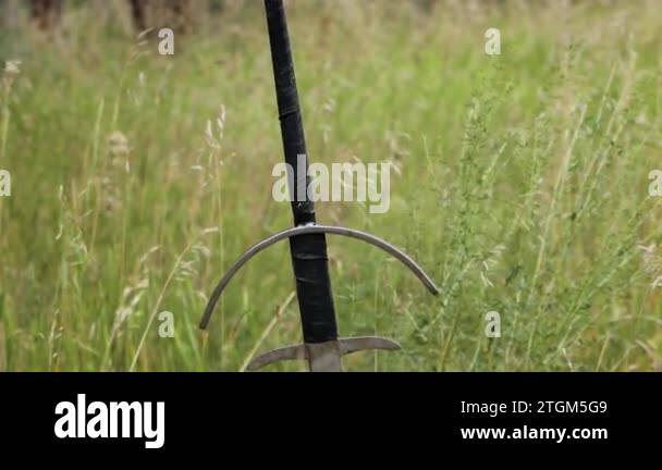 Smooth camera movement, selective focus, a two-handed sword stuck in ...