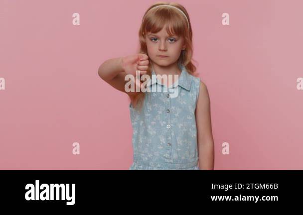 Dislike. Upset young preteen child girl kid showing thumbs down sign ...