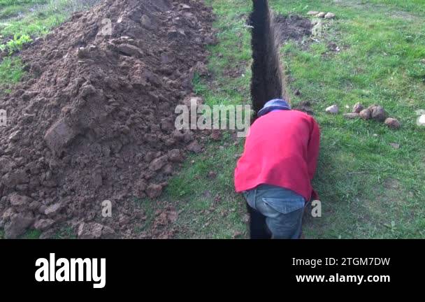 Man digging a very narrow ditch Stock Video Footage - Alamy