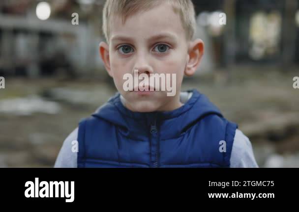 Portrait of the child on the devastation background. A sad little boy ...
