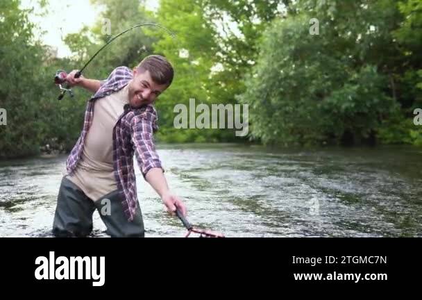 Fisherman with fishing rod on the river. Brown trout fish. Summer ...