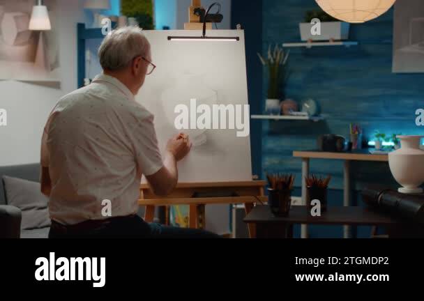 Senior man looking at vase design inspiration to draw sketch on canvas ...