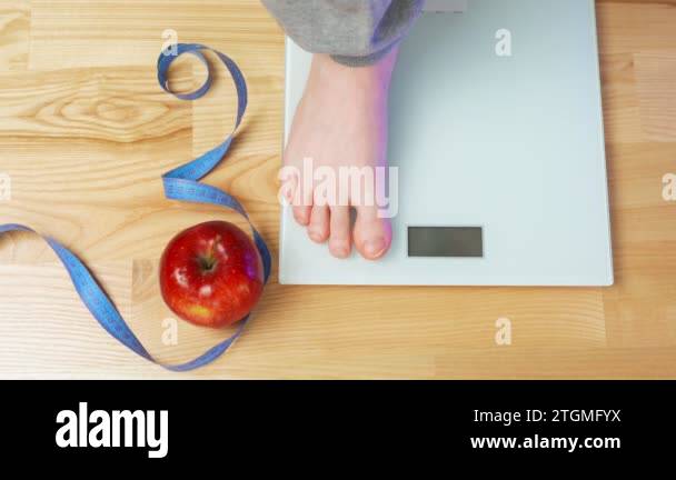 A woman gets on the scales and sees her weight of 63 kg. The number ...