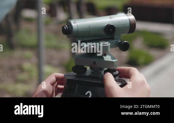 Construction worker uses optical level on construction site. Civil ...