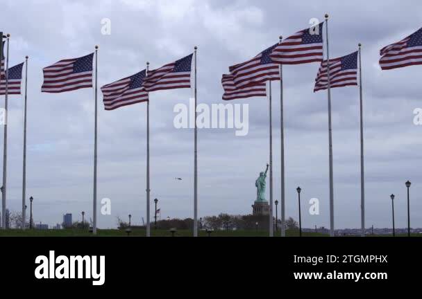 United States of America flags in slow motion. Statue of liberty in ...